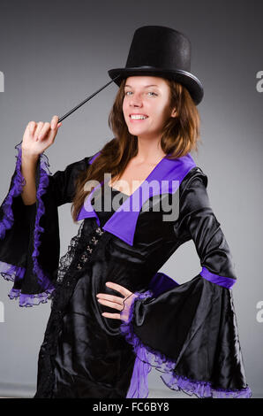 Pretty magician girl holding stick against gray Stock Photo - Alamy