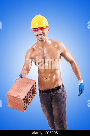 Muscular builder with bricks on white Stock Photo - Alamy