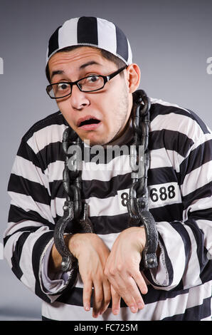 Emotional prisoner in striped uniform with handcuffs on black ...