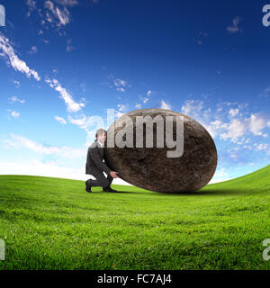 An image of a man rolling a rock uphill Stock Photo: 33940973 - Alamy