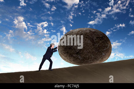 An image of a man rolling a rock uphill Stock Photo: 33940973 - Alamy