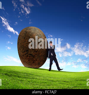 An image of a man rolling a rock uphill Stock Photo: 33940973 - Alamy