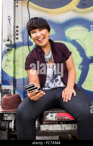 Asian woman with a hat and camera using a mobile phone isolated over ...