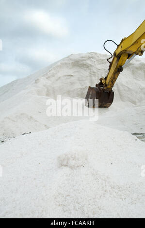 Excavator digging pile white salt Stock Photo - Alamy