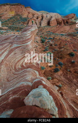 Dark ominous clouds glide past the swirling red rock striations of ...