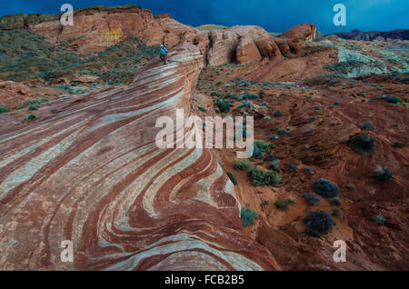 Dark ominous clouds glide past the swirling red rock striations of ...