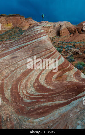 Dark ominous clouds glide past the swirling red rock striations of ...