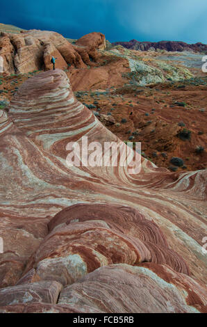 Dark ominous clouds glide past the swirling red rock striations of ...