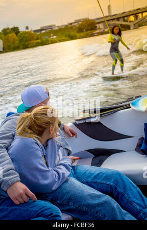 Group of young people wake surfing behind boat Stock Photo - Alamy