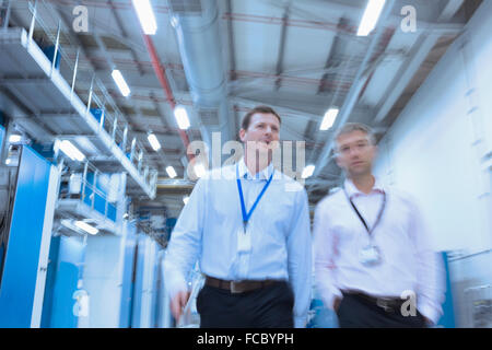Two businessmen walking in factory shop floor Stock Photo - Alamy