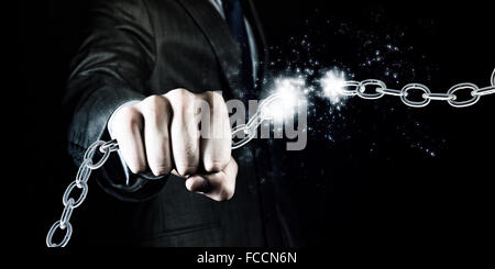 Powerful businessman holding chain in his fist Stock Photo - Alamy