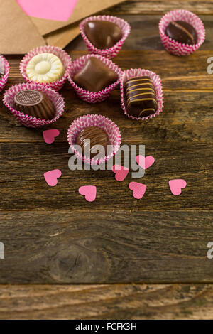 Assorted chocolates on rustic wood table Stock Photo - Alamy