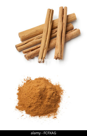 Cinnamon sticks and ground powder on white reflective background ...