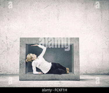 Young businesswoman trapped in stone cube in wall Stock Photo - Alamy