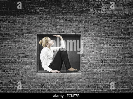 Young businesswoman trapped in stone cube in wall Stock Photo - Alamy