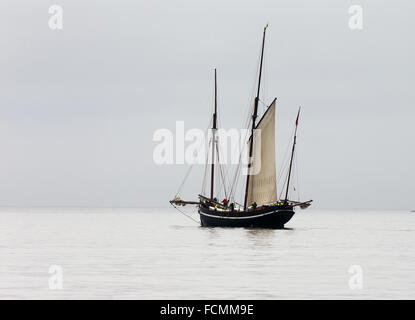 Ancient fishing boat, a Cornish lugger, becalmed off Newlyn, Cornwall ...