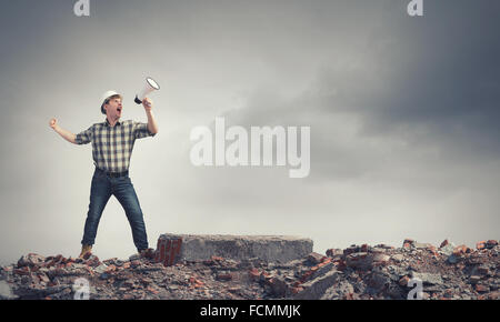 Young man engineer screaming emotionally in megaphone Stock Photo - Alamy