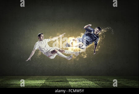 Two football players in jump fighting for ball Stock Photo - Alamy