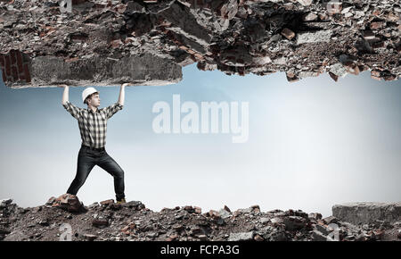 Strong man in uniform lifting wall above head Stock Photo - Alamy