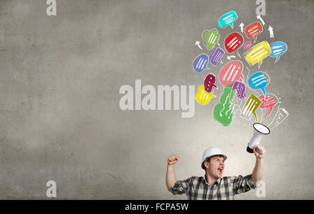 Young man engineer screaming emotionally in megaphone Stock Photo - Alamy