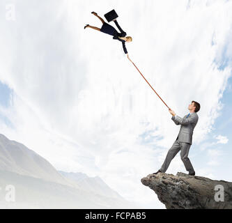 Young man on lead of colleague trying to escape Stock Photo - Alamy
