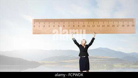 Young businesswoman measuring something with big ruler Stock Photo - Alamy