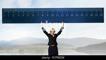 Young businesswoman measuring something with big ruler Stock Photo - Alamy