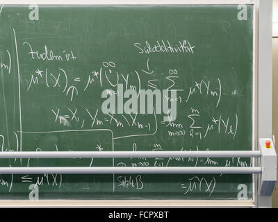 Handwritten mathematical formulas on blackboard written with chalk ...