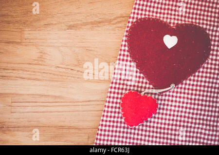 checkered cotton fabric and heart felt decoration on a wood background ...