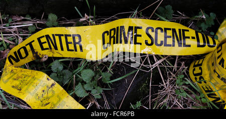 Yellow CRIME SCENE tape - Do not enter - between wooden posts with ...