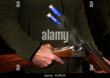 Break-action shotgun in the moment of ejecting empty shells Stock Photo ...