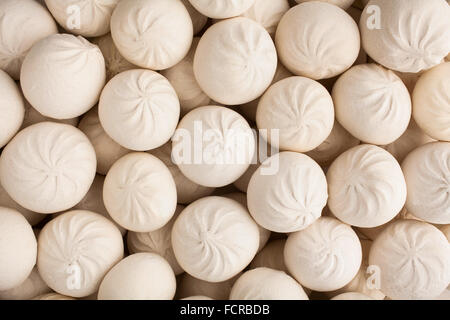 A pattern of raw, frozen dumplings on a light blue background. View ...