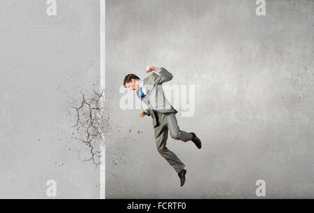 Businessman breaking stone wall with karate punch Stock Photo - Alamy