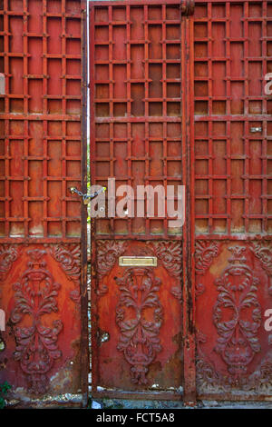 Closed red painted iron gate with handle, lock and stainless steel ...