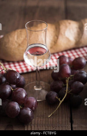 italien Grappa with Grape and Bread on wooden Table Stock Photo - Alamy
