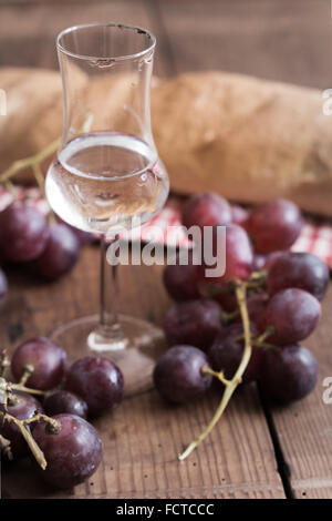 italien Grappa with Grape and Bread on wooden Table Stock Photo - Alamy