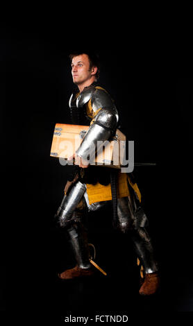 Young man as a medieval knight on dark studio background. Portrait of ...