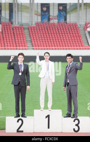 A MAN AT THE PODIUM WITH TWO OTHER MEN ON STAGE Stock Photo - Alamy