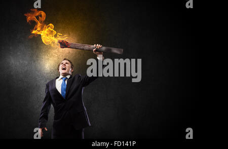 Young businessman holding burning torch in hand Stock Photo - Alamy
