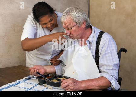 Grumpy old grandpa in nursing home receiving medication by a nurse ...