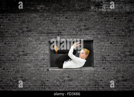 Young woman trapped in stone cube in wall Stock Photo - Alamy