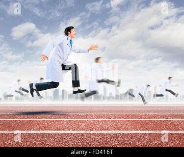Funny image of young running doctor in white uniform Stock Photo - Alamy