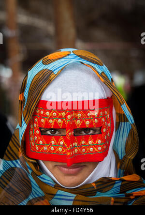 a bandari woman wearing a traditional gold mask called the burqa with a ...
