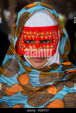 a bandari woman wearing a traditional gold mask called the burqa with a ...