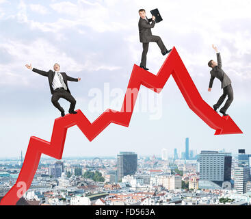 Set of businessmen trying not to fall from arrow Stock Photo - Alamy