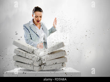 Image of businesswoman breaking bricks with hand Stock Photo - Alamy