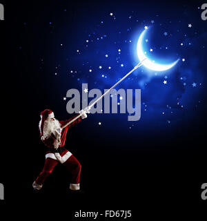 Image of Santa Claus pulling moon with rope Stock Photo - Alamy