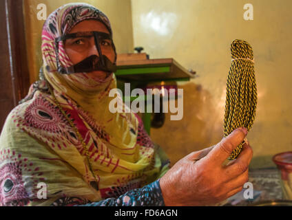 a bandari woman with a traditional mask and showing an ice cream short ...