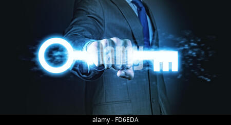 Powerful businessman holding key in his fist Stock Photo - Alamy
