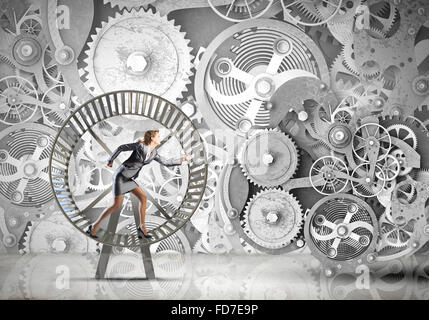 Young businesswoman running in wheel of gears mechanism Stock Photo - Alamy